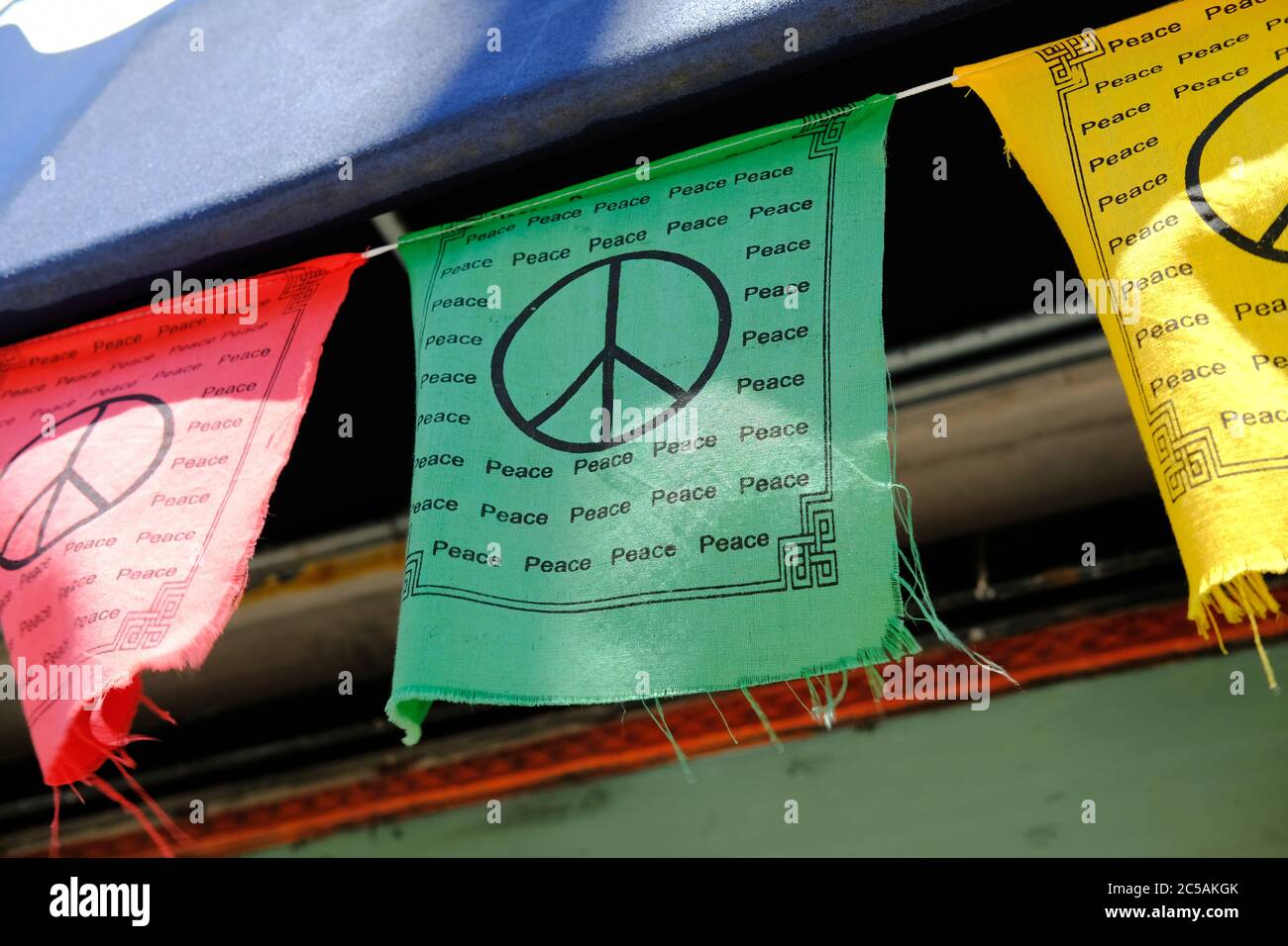 Colorful peace string flags hanging in the wind from the rafters of a ...