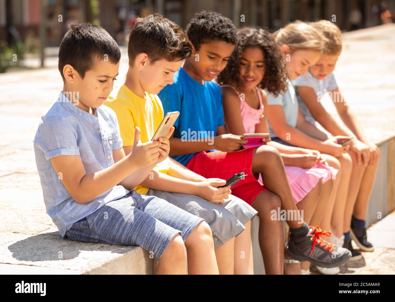 Kids using phones outdoors, concept of children addiction to social ...