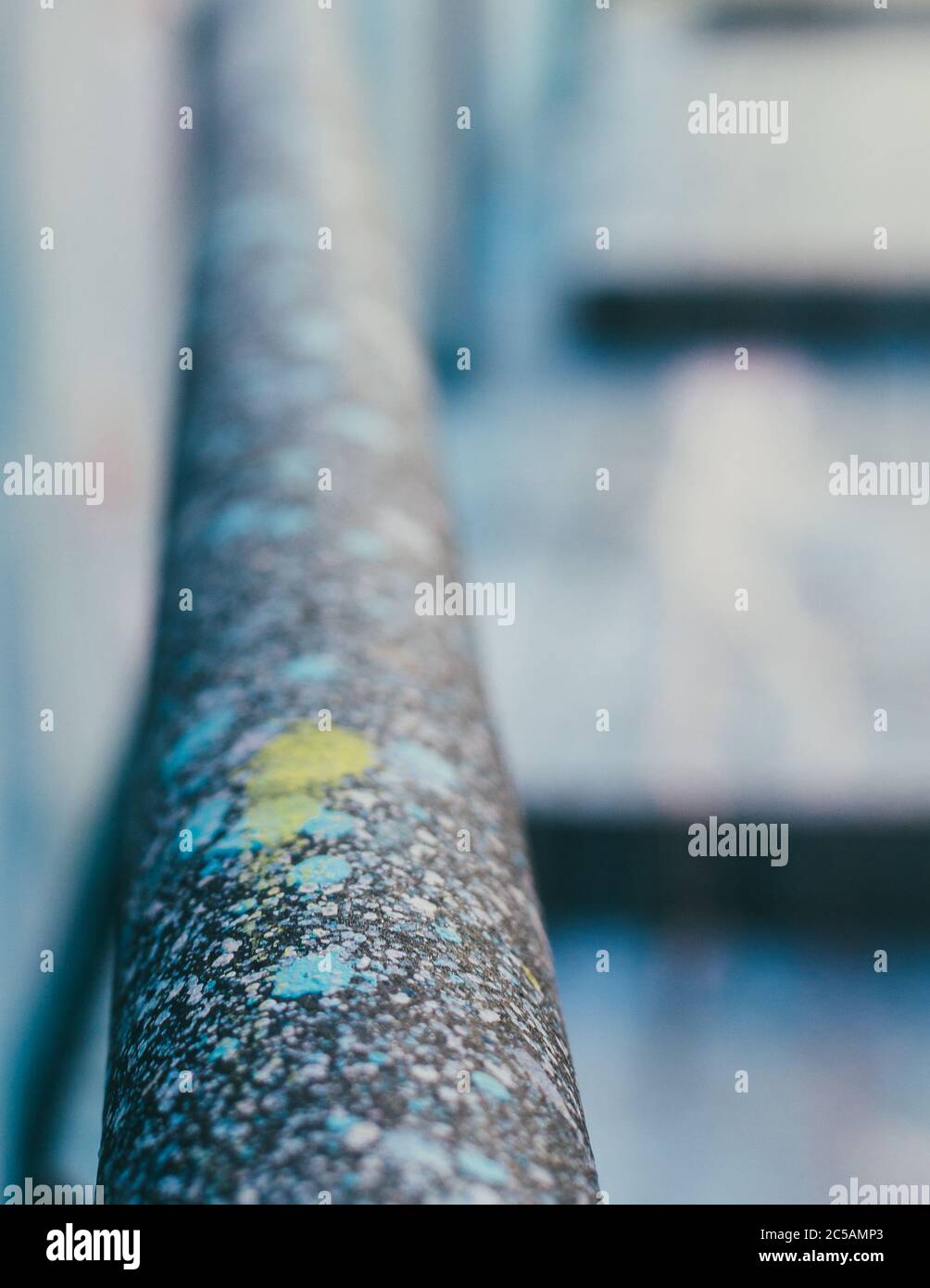 Vertical high angle shot of a metal pipe covered in drops of different ...