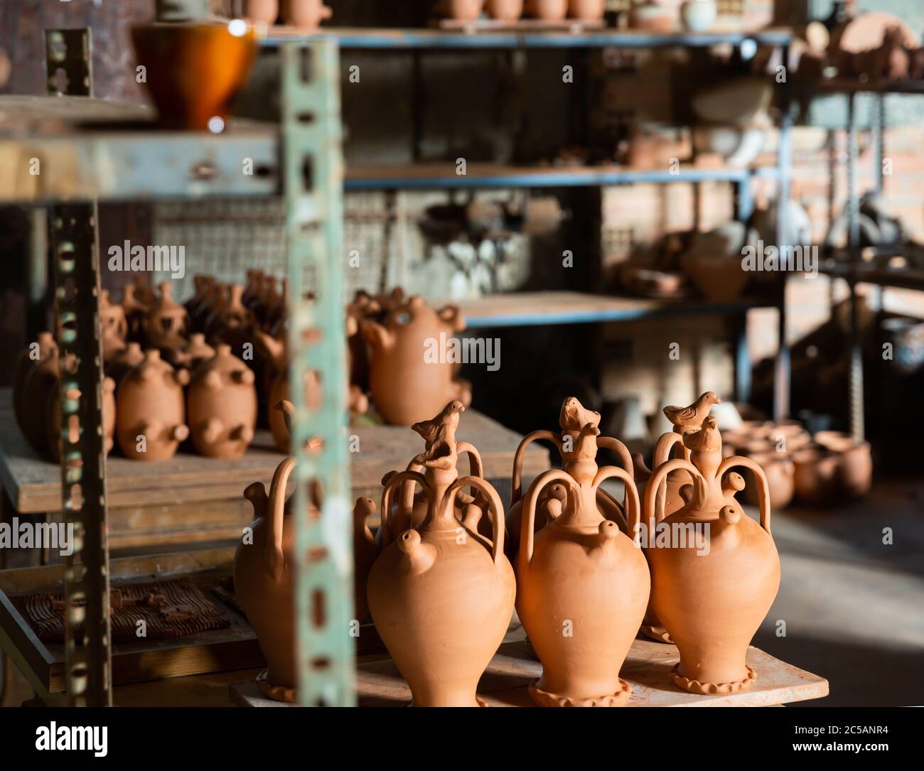 Finished pottery production on shelves and on floor in pottery studio ...