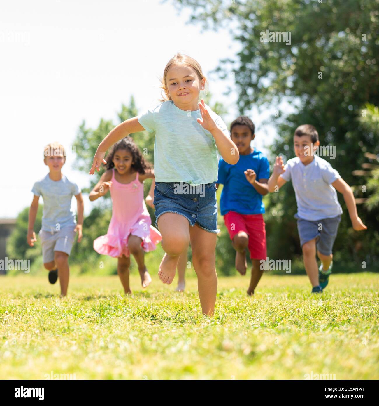 Group of happy kids running in race in the street and laughing in park ...