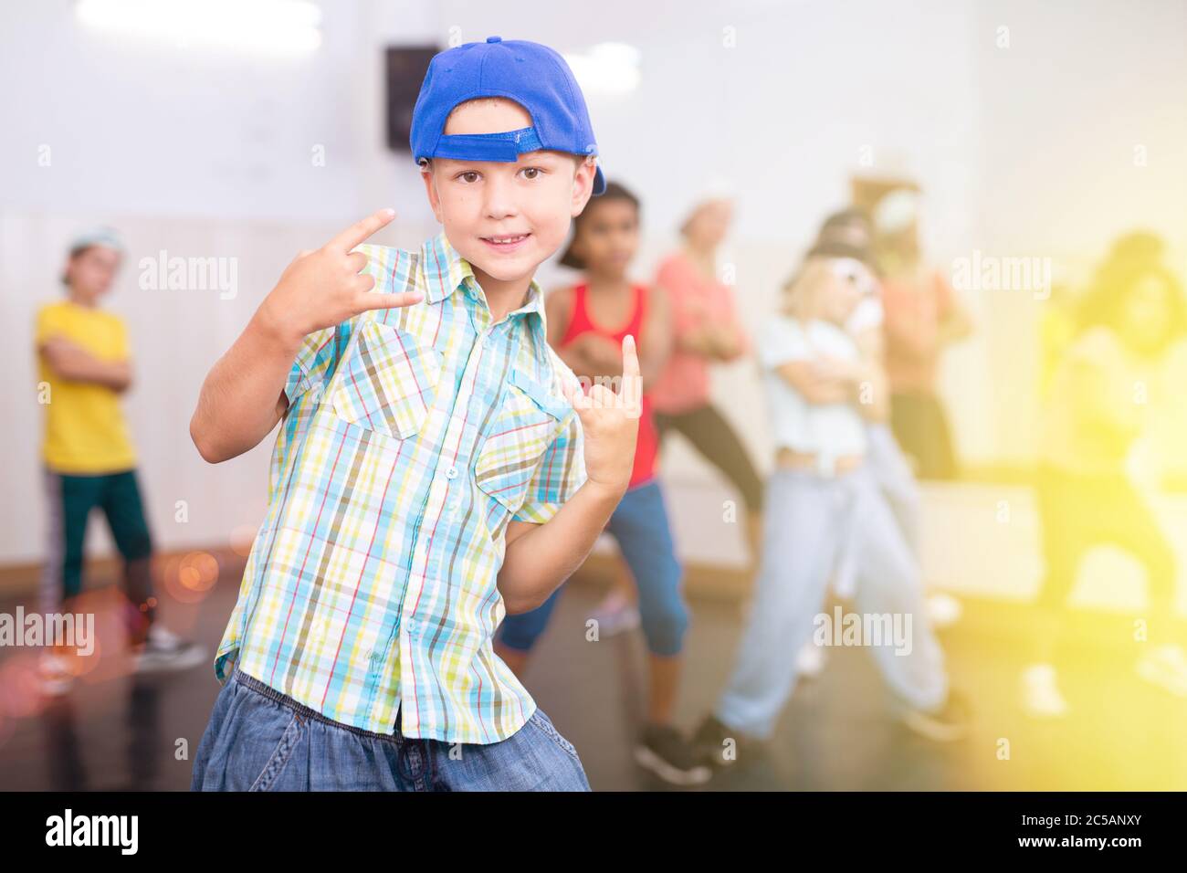 Portrait of emotional boy doing hip hop movements during group class in ...