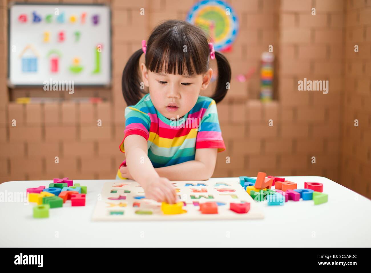 toddler girl learning letter blocks for homeschooling Stock Photo - Alamy