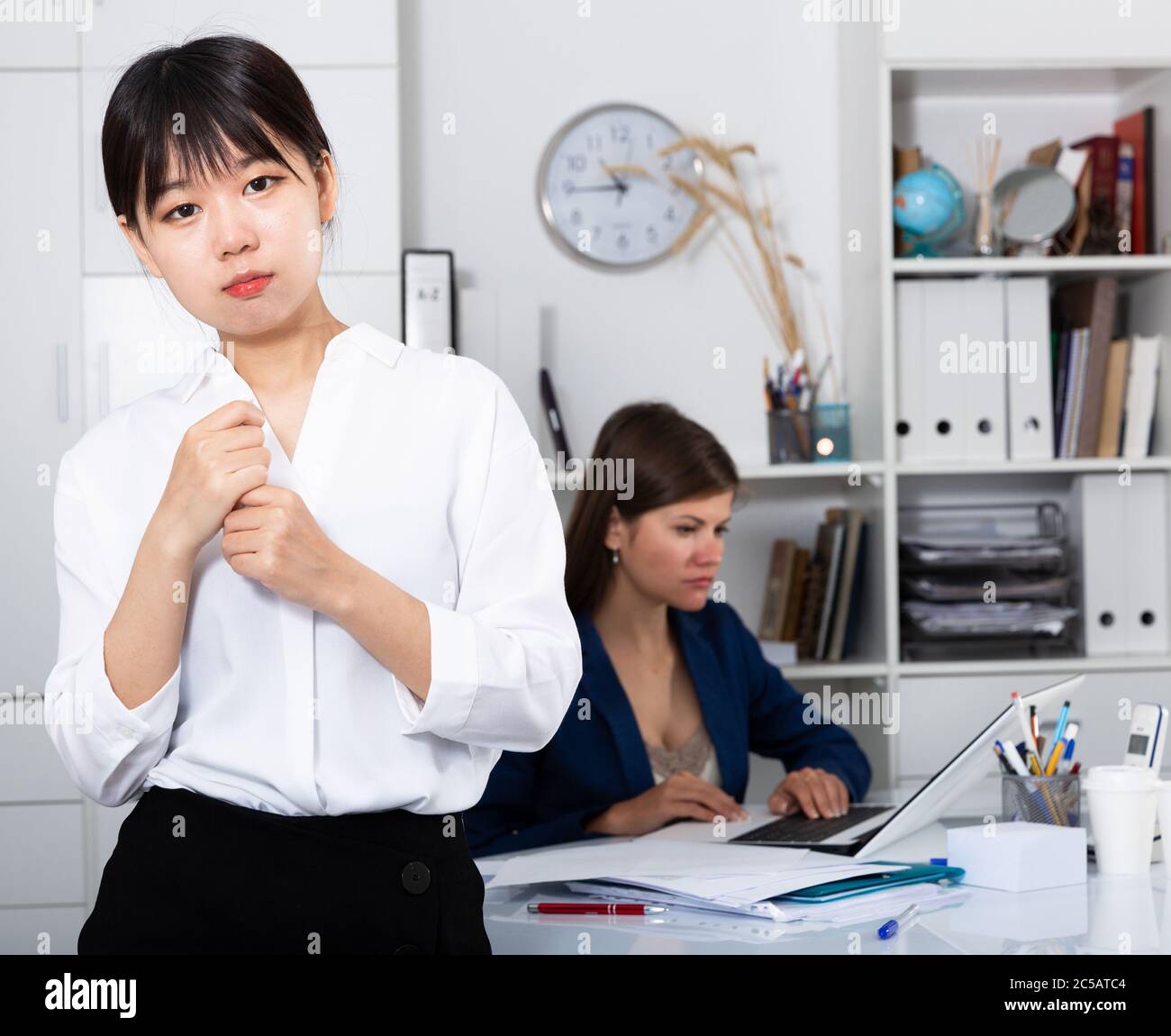 Unhappy and crying asian woman standing in office with working ...