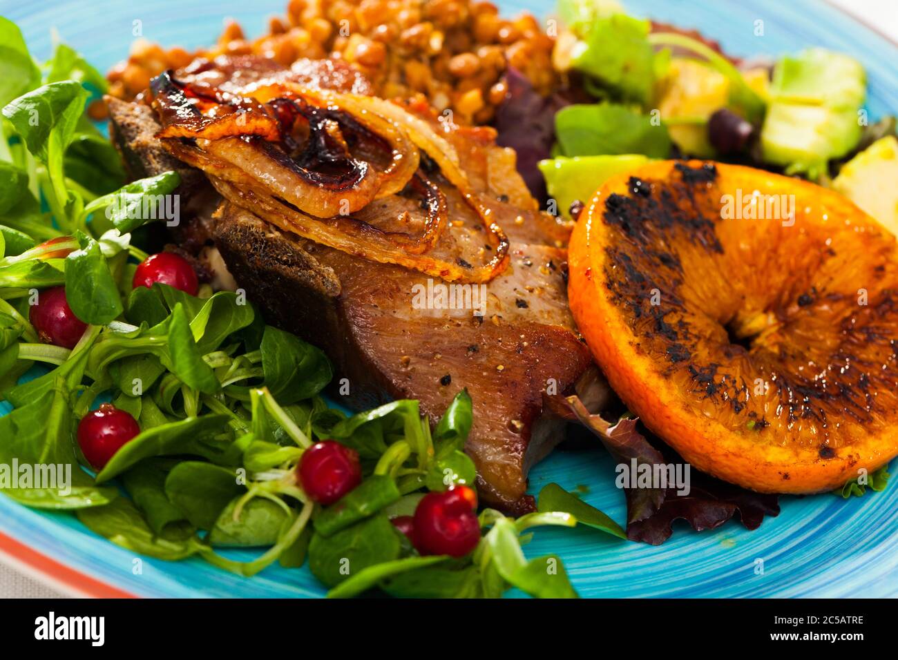 Delicious roasted pork shin served with stewed lentils, fresh avocado ...
