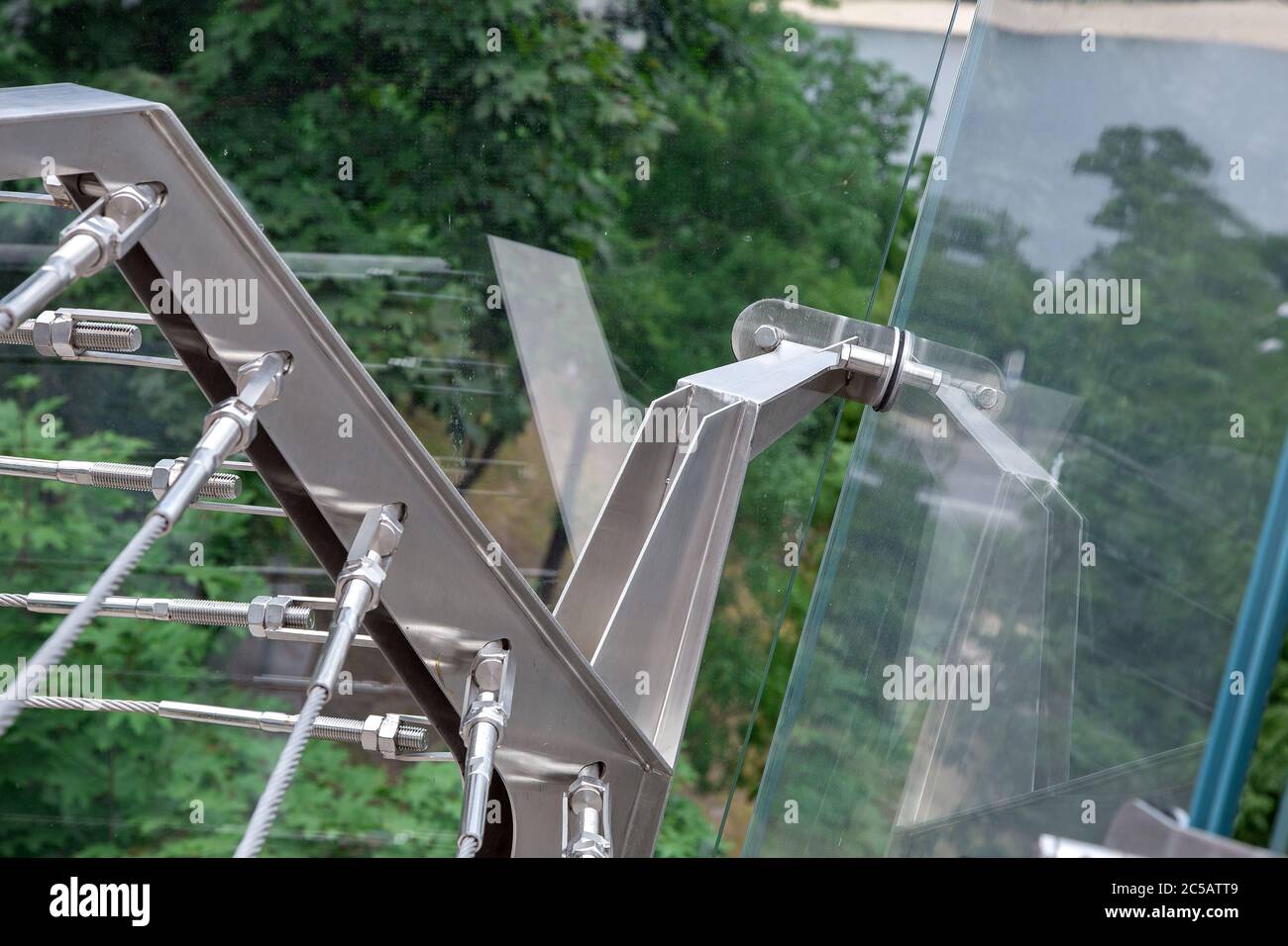 a corner of a glass bridge with tension steel cables and a cable ...
