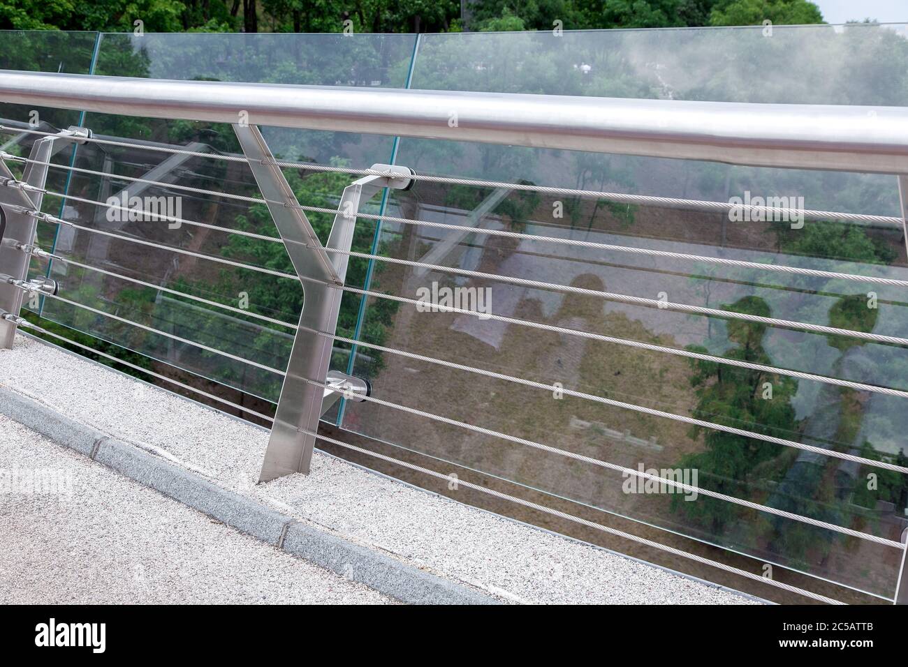 construction of a glass bridge with steel fixtures with a railing and a ...