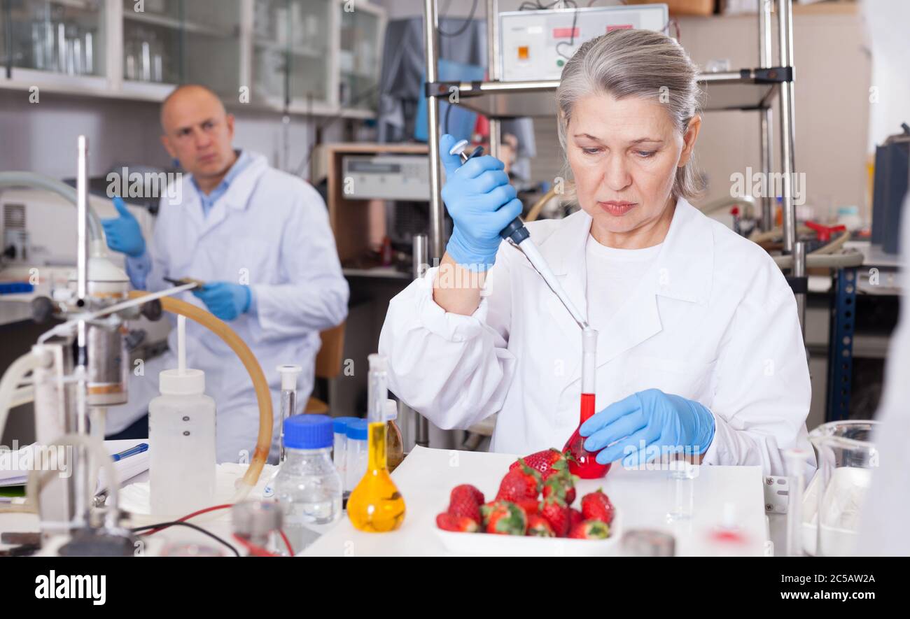 Professional female geneticist working in laboratory, conducting ...