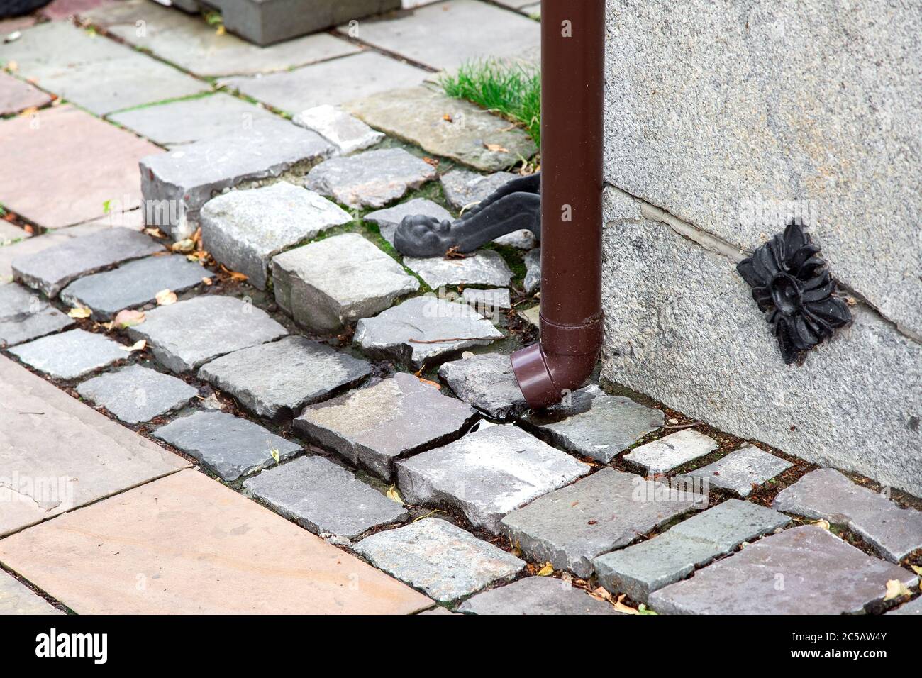 rain pipe rain system on the corner of the house near the stone ...
