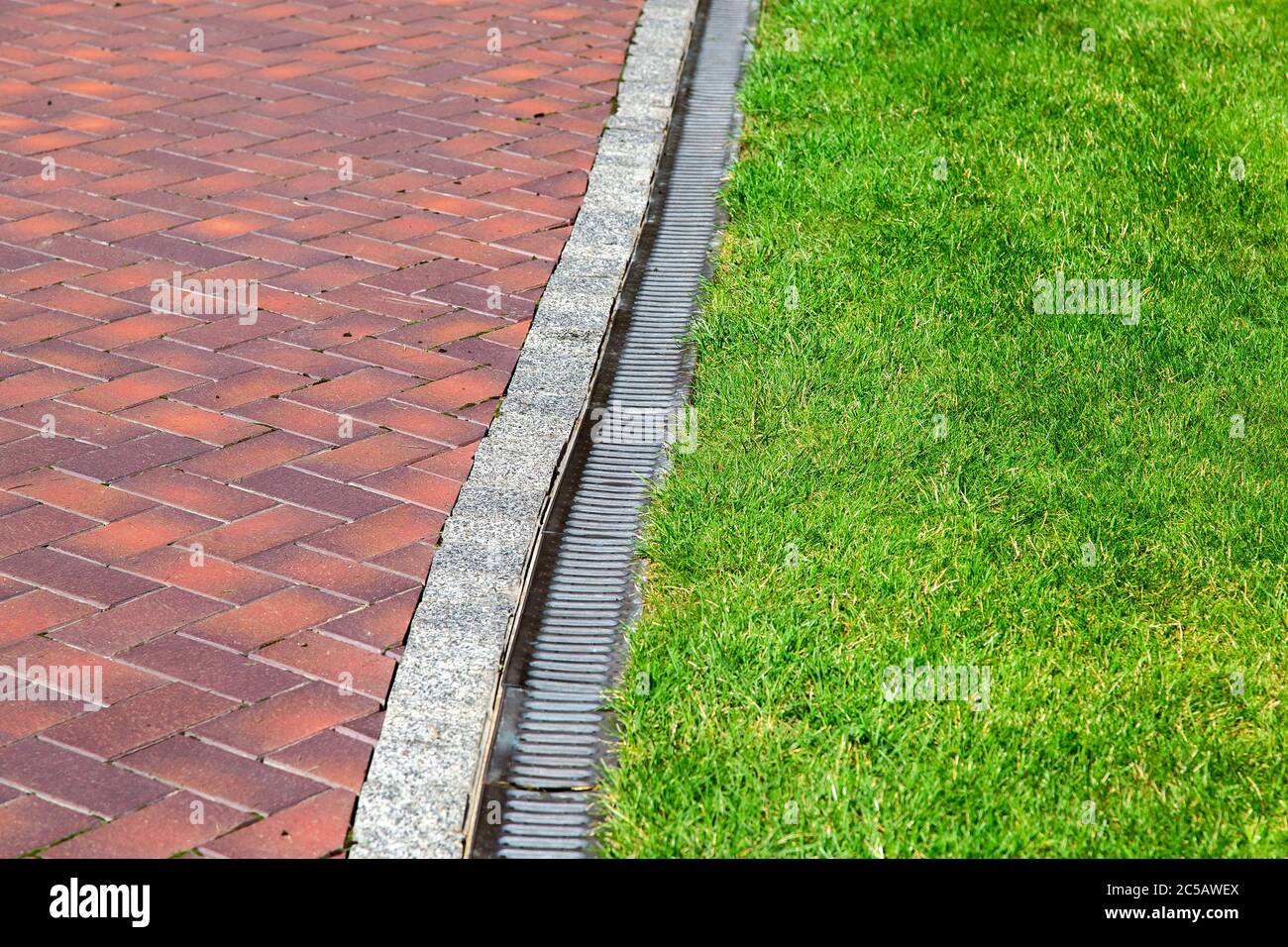 iron gutter with grate to the drainage system on the side of the ...