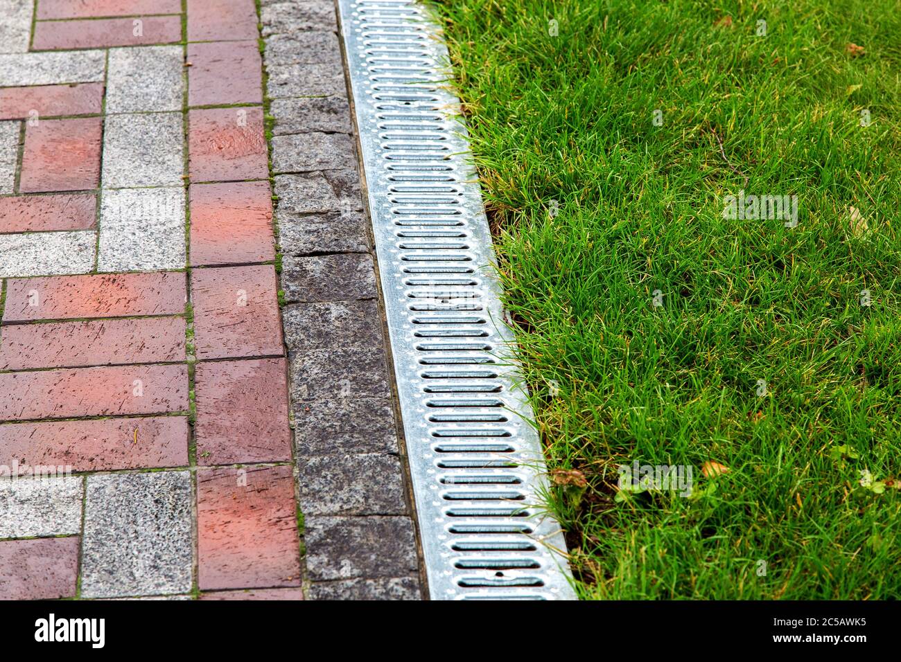 An iron gutter with grate to the drainage system on the side of the ...