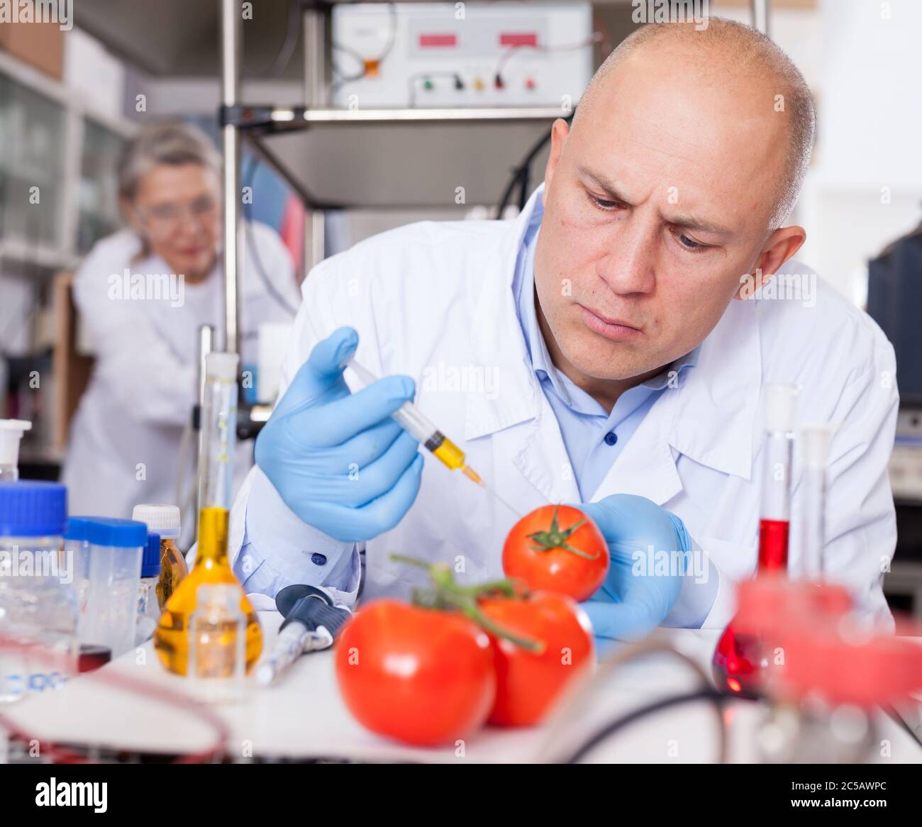 Experienced biochemist performing GMO experiments in modern laboratory ...