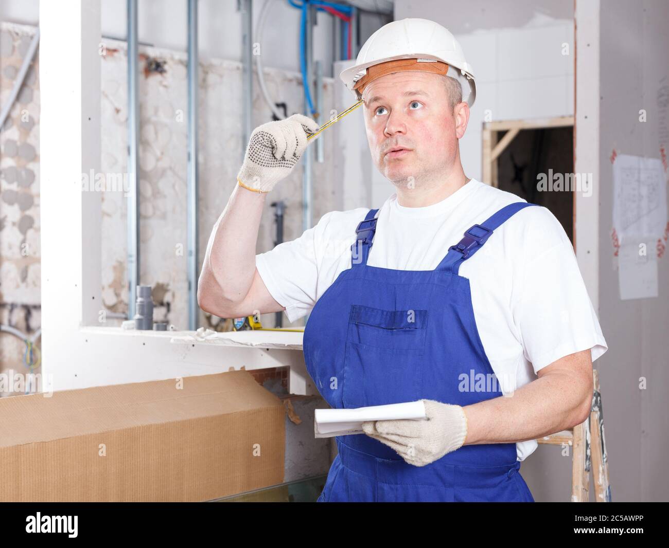 Scared and confused male contractor looking at room and determining ...