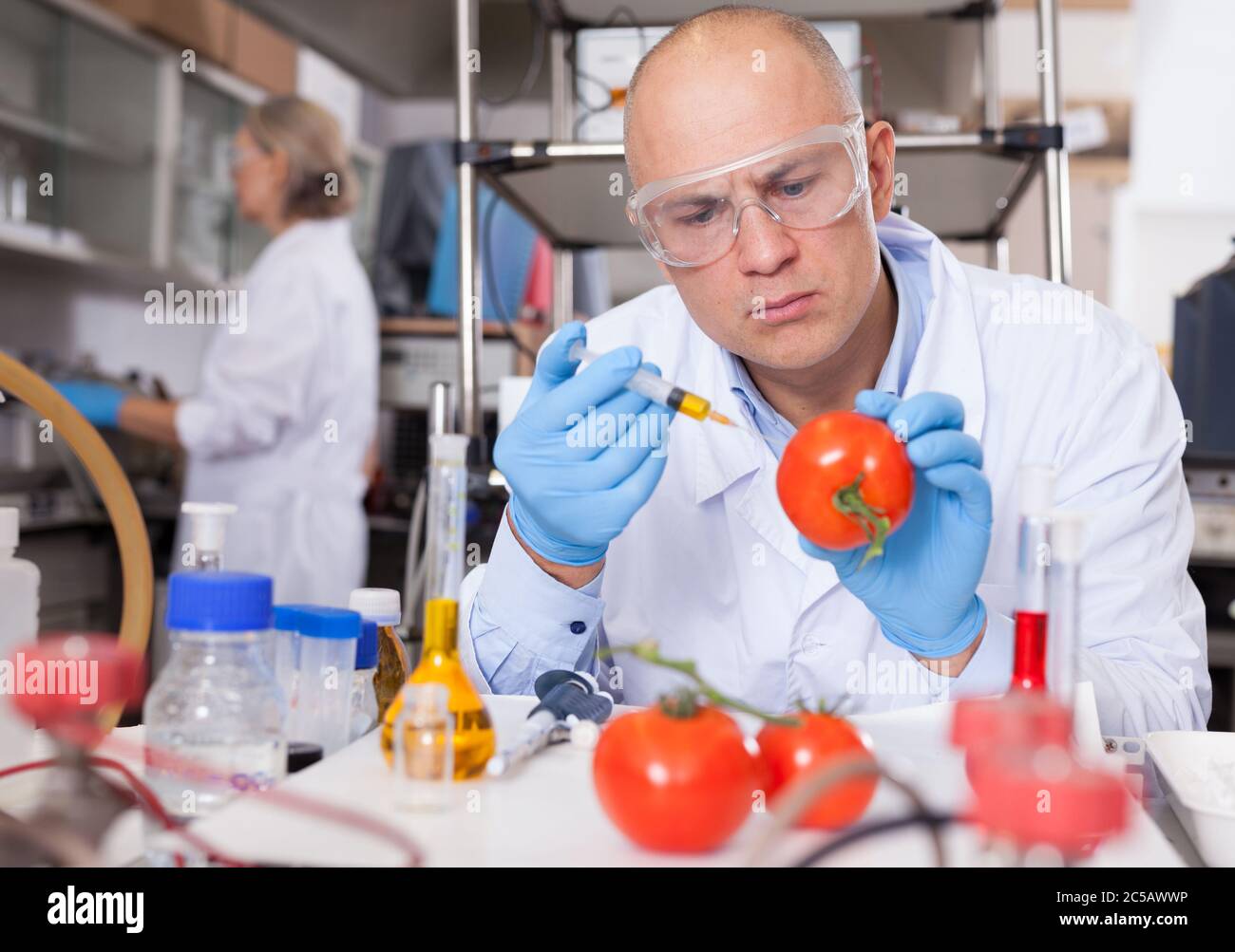 Experienced biochemist performing GMO experiments in modern laboratory ...