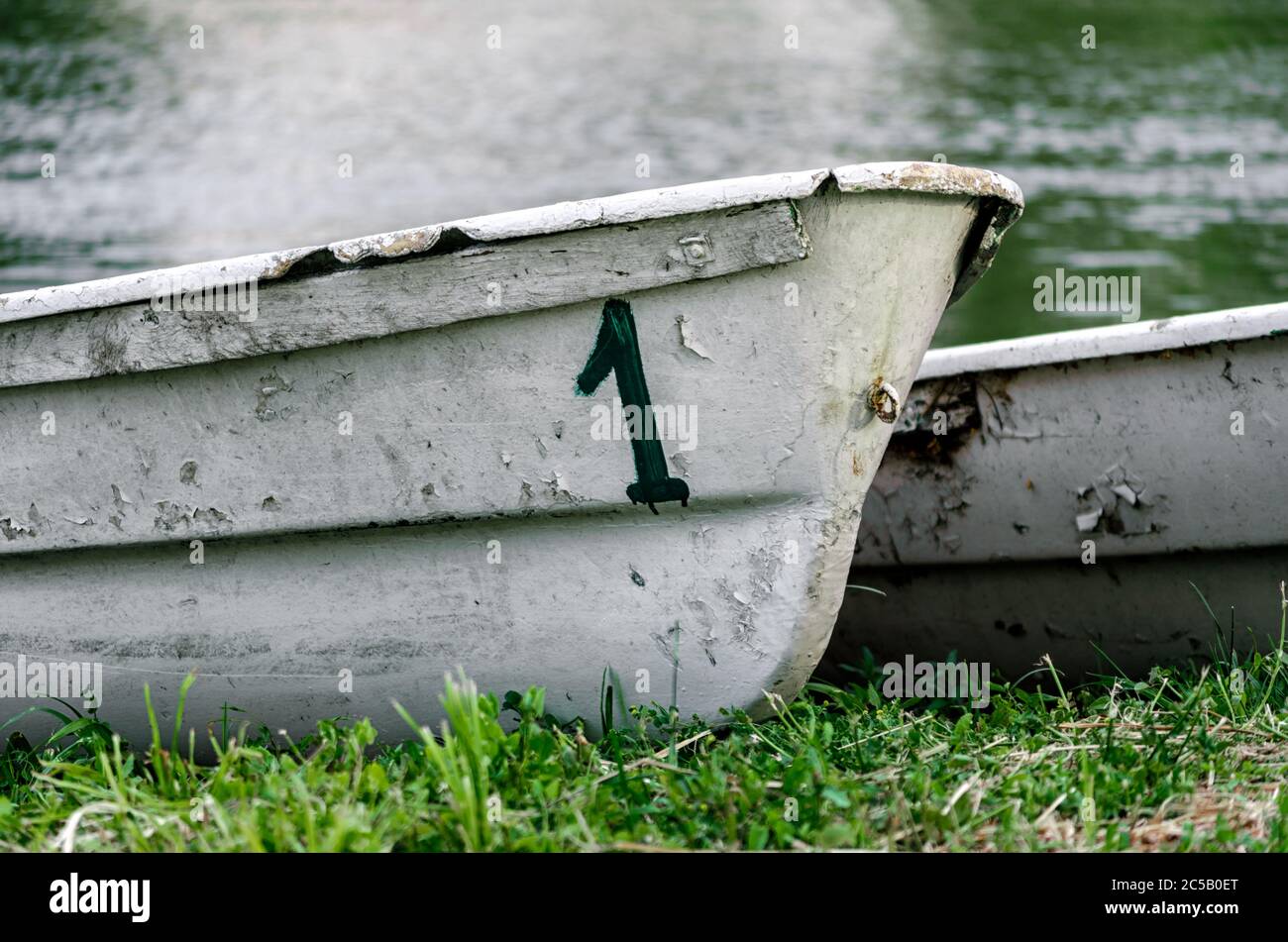old boat number one on the river bank on green grass without people ...