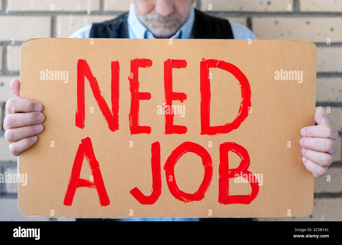 Unemployed during crisis. White man holds poster in his hands in search ...