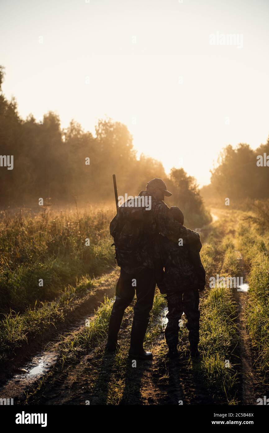 Father and son hunting together. Walking the road after the bird hunt ...
