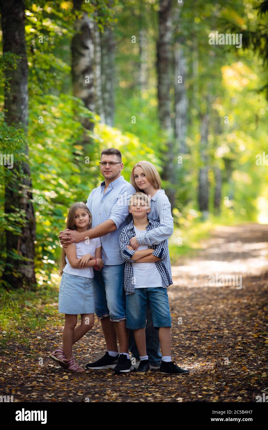 Happy family outdoors smiling in a summer forest Stock Photo - Alamy