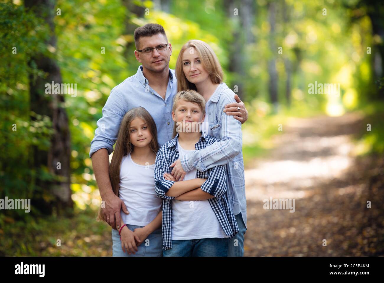 Happy family outdoors smiling in a summer forest Stock Photo - Alamy