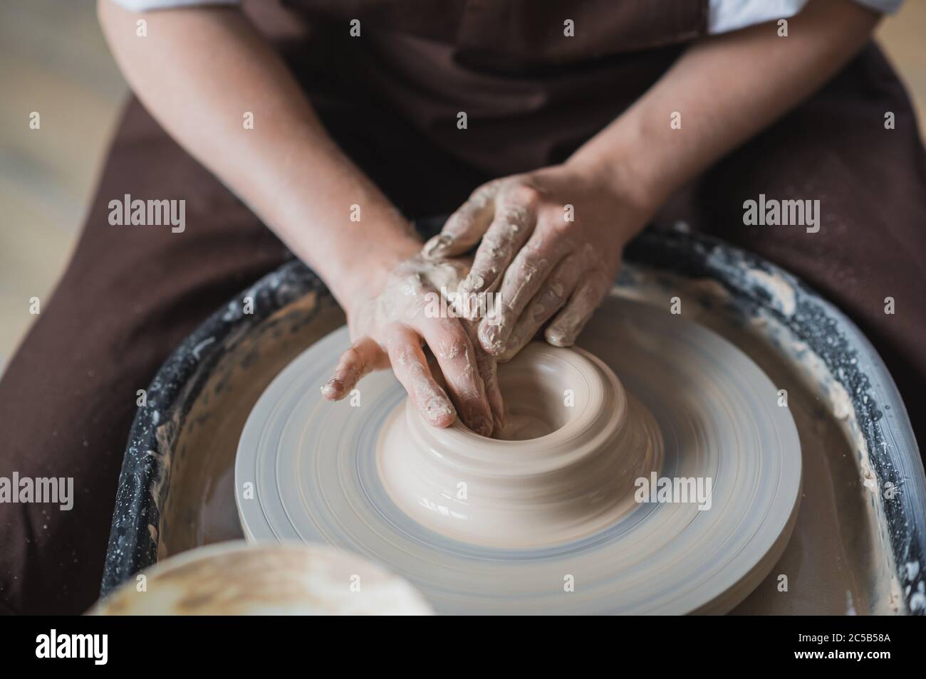 Close-up view of woman hands working on pottery wheel and making clay ...