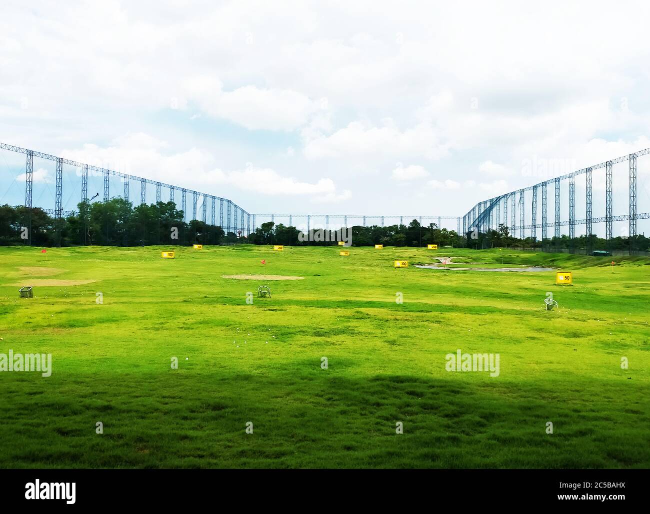 Golf driving range on cloudy blue background Stock Photo - Alamy