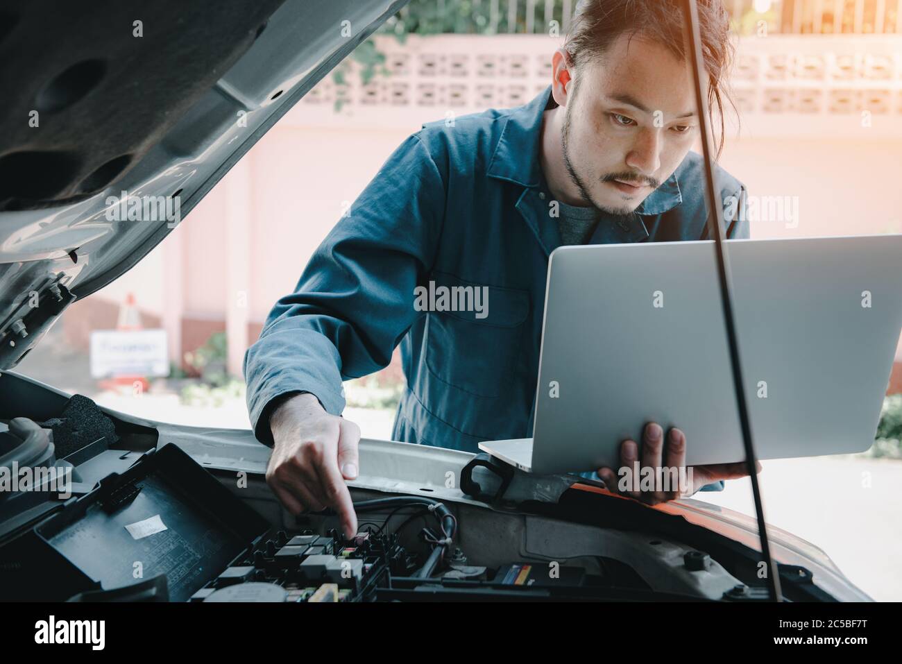 Mechanic Engineer is Diagnosing Car Engine and Electric Adjusting ...