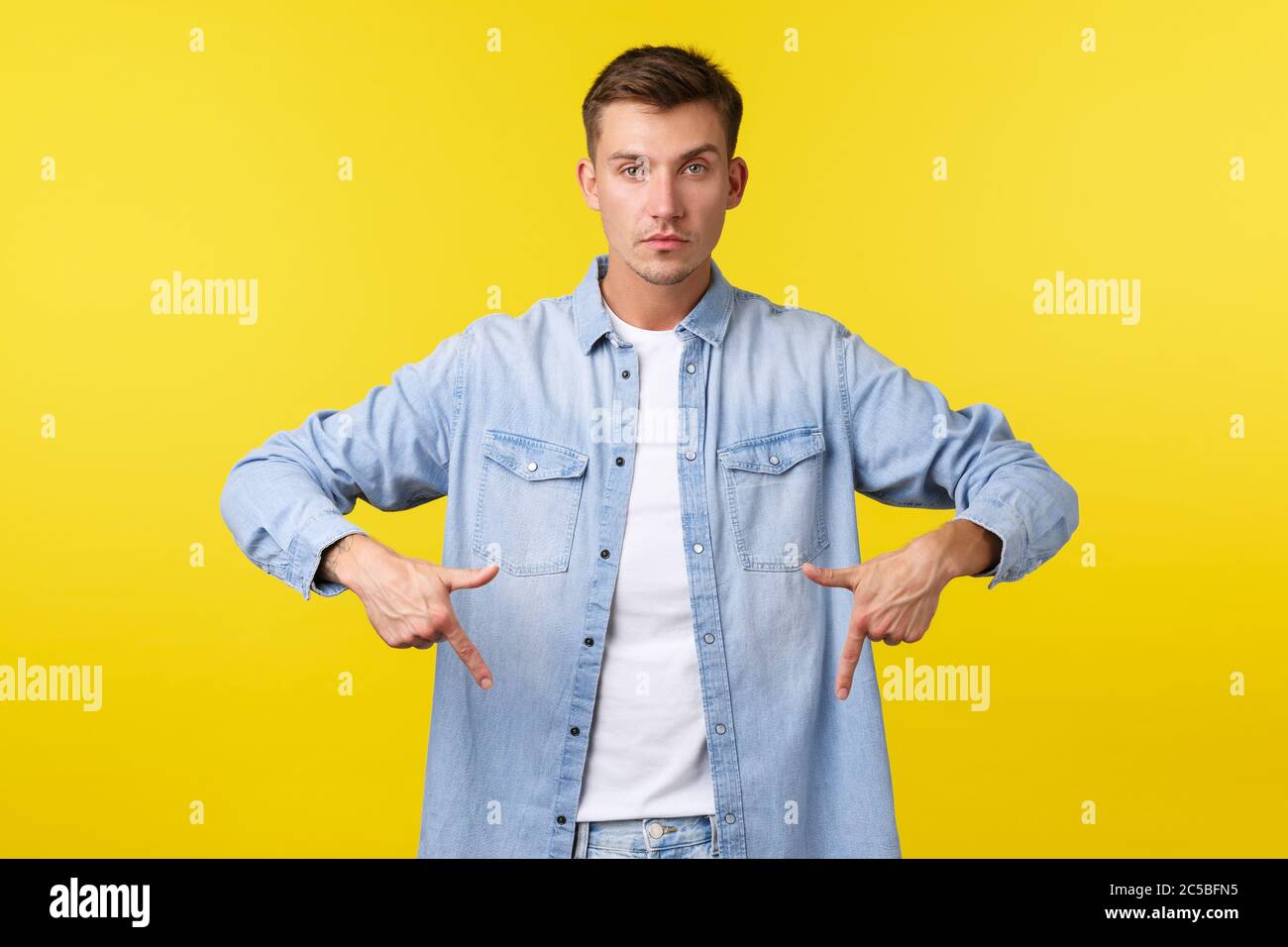 Serious-looking queer guy in casual clothes looking sassy and confident ...