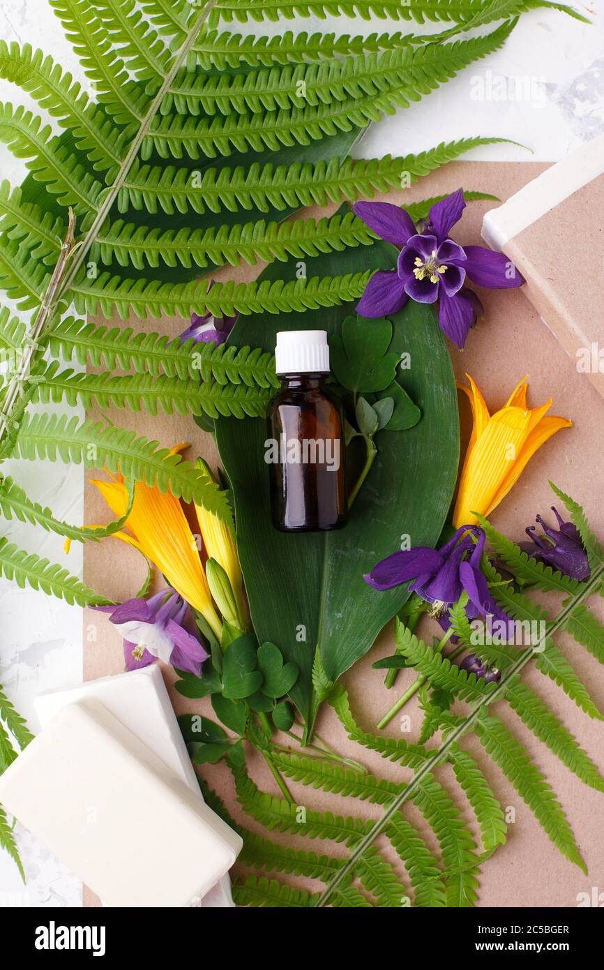Natural organic essential oil packaging mock up with leaves and flowers ...
