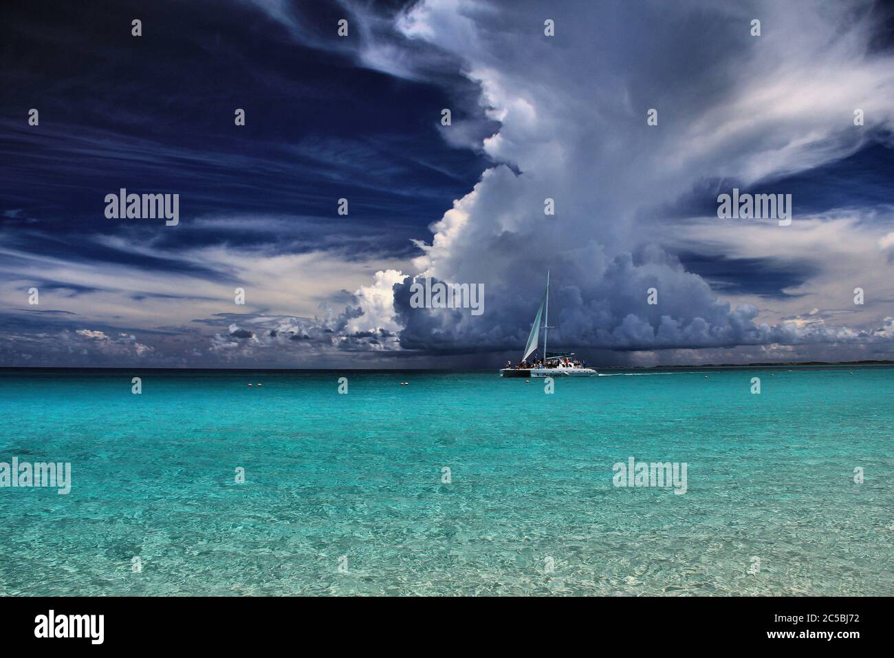 Dramatic beach scene with deep blue skies, white clouds and clear blue ...