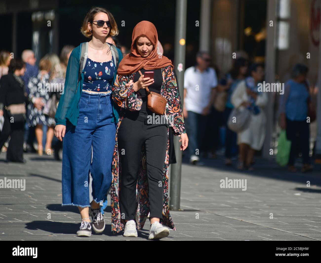 Italian young girls, one of them muslim, listening music togheter while ...