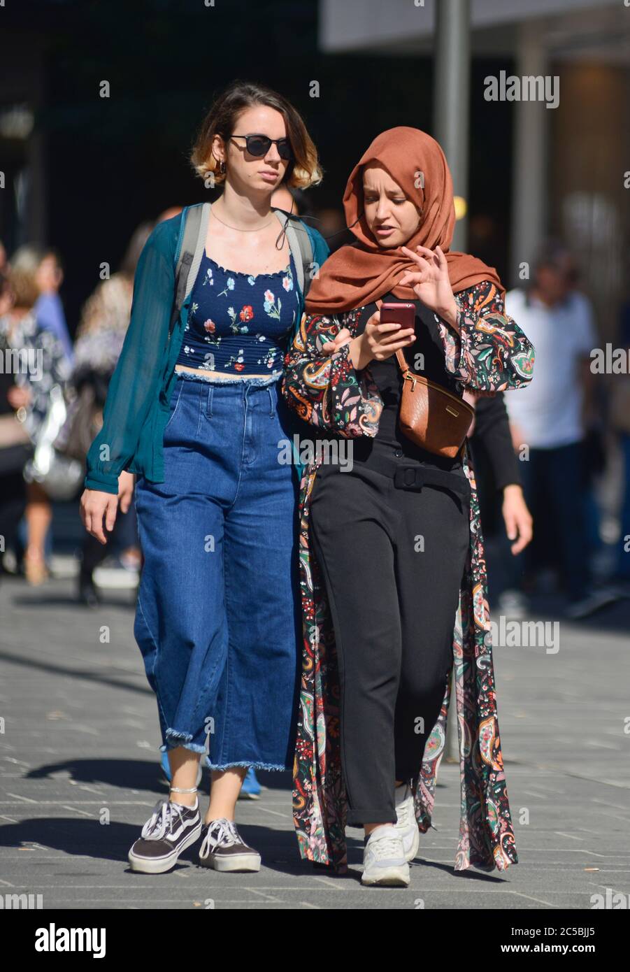 Italian young girls, one of them muslim, listening music togheter while ...