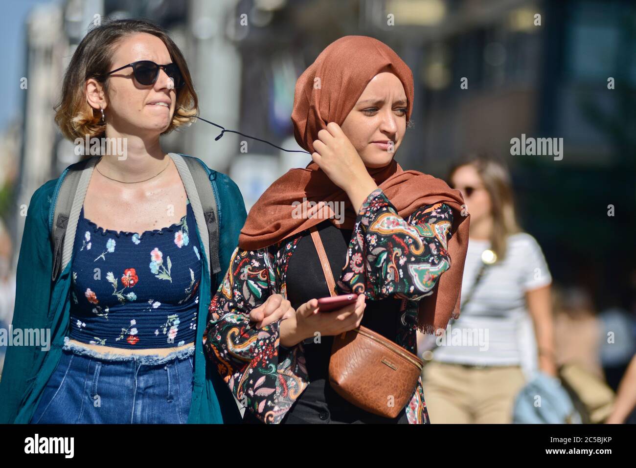 Italian young girls, one of them muslim, listening music togheter while ...