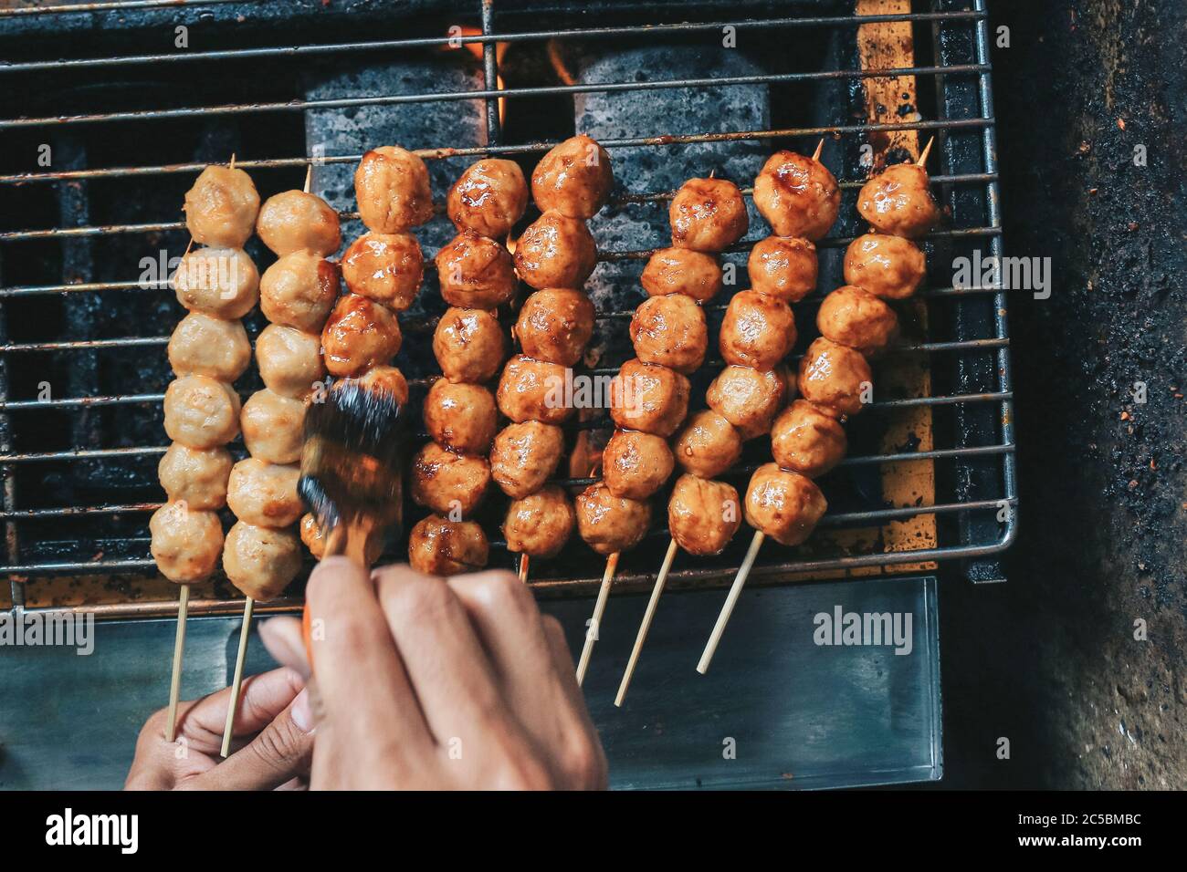 Cooking Barbecue Meatball Satay in grilling stove. This is Indonesian ...