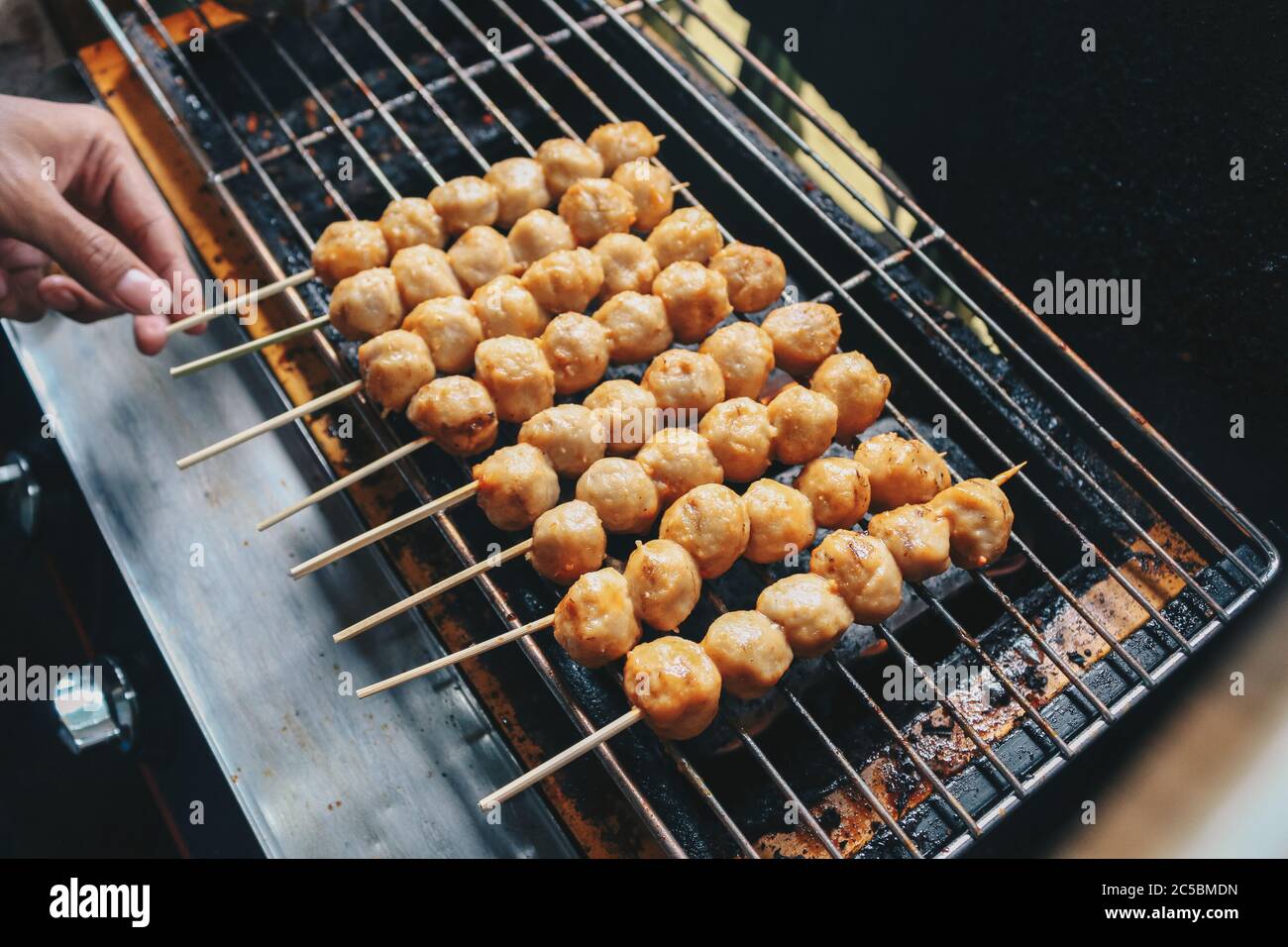 Cooking Barbecue Meatball Satay in grilling stove. This is Indonesian ...