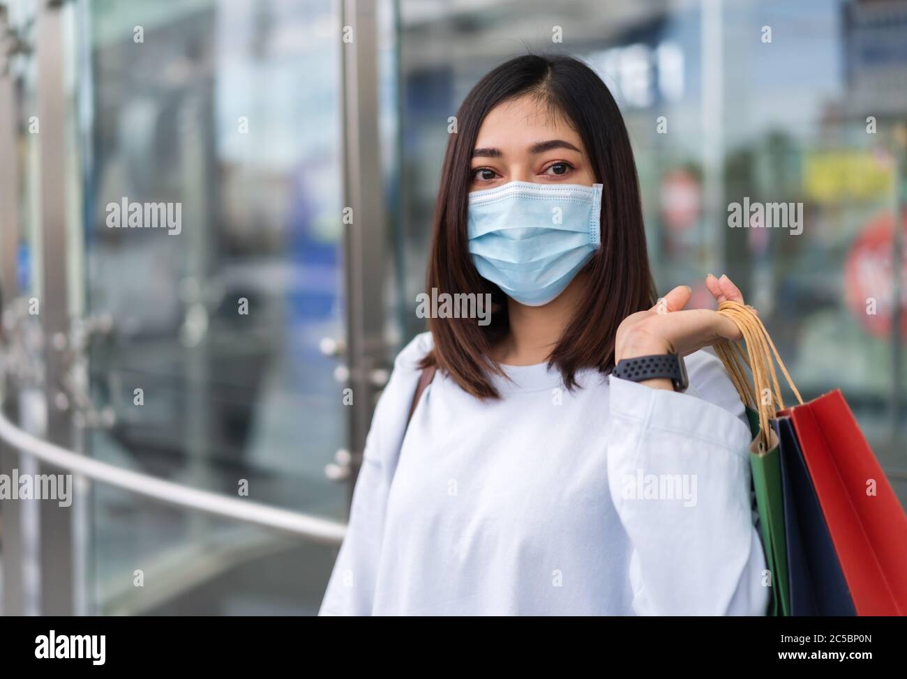 young woman shopping with bag at mall and her wearing medical mask for ...