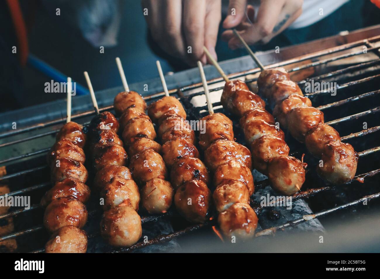 Cooking Barbecue Meatball Satay in grilling stove. This is Indonesian ...