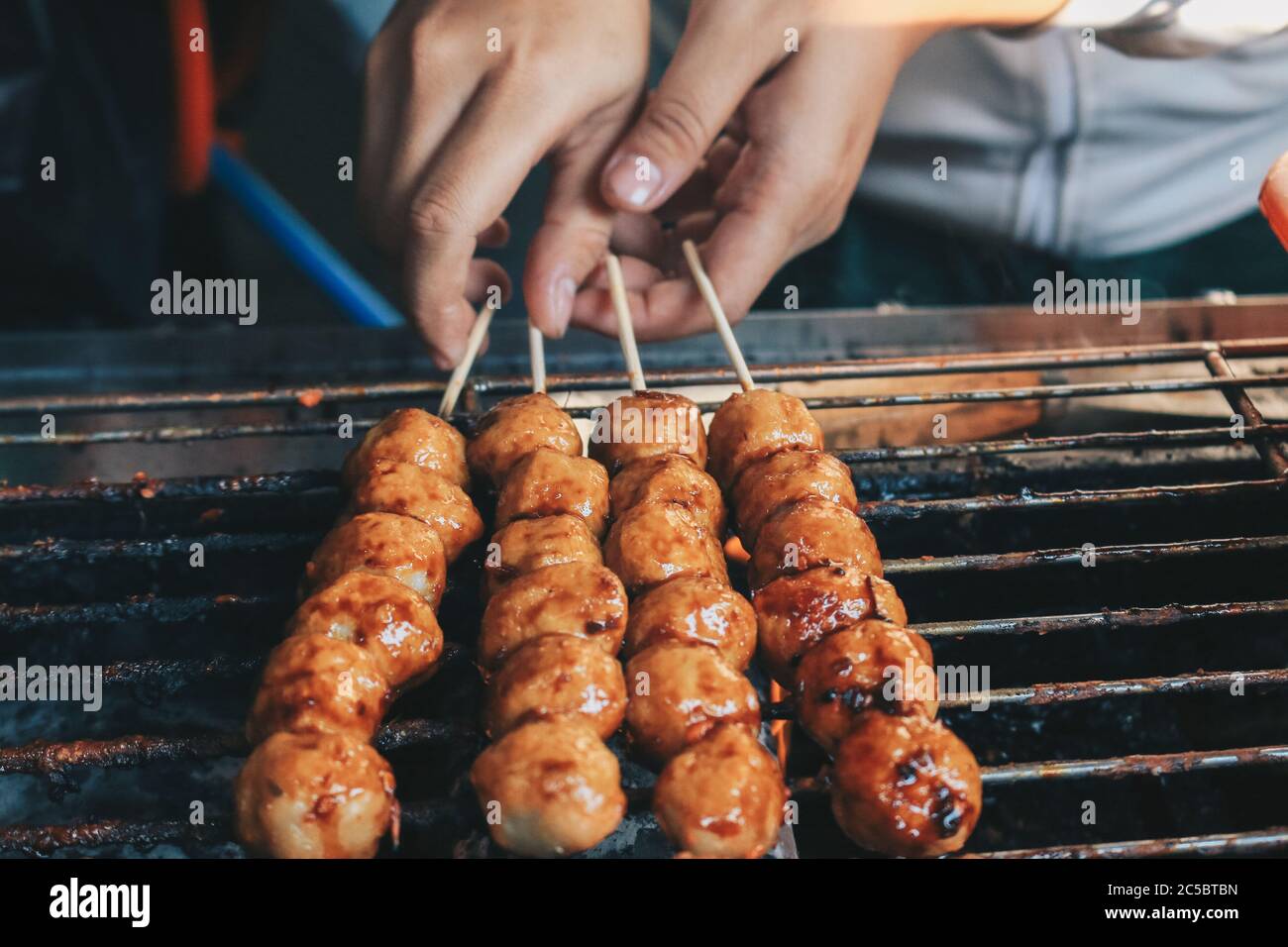 Cooking Barbecue Meatball Satay in grilling stove. This is Indonesian ...