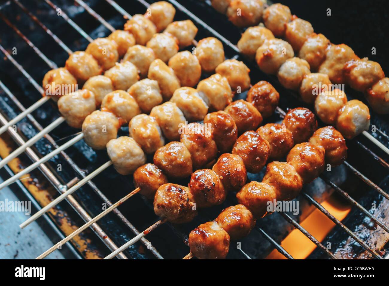 Cooking Barbecue Meatball Satay in grilling stove. This is Indonesian ...