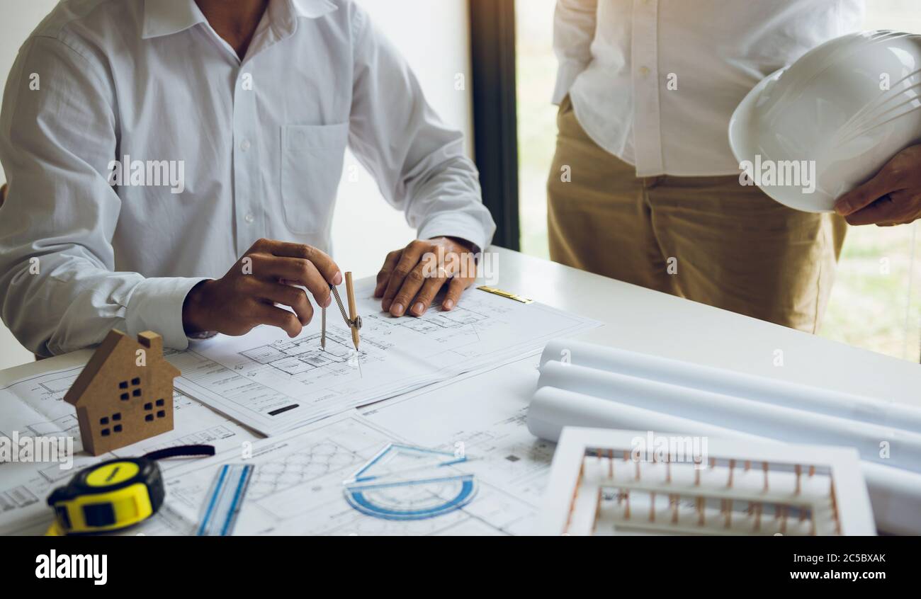 Two architect working at construction site and compass drawing pointing ...