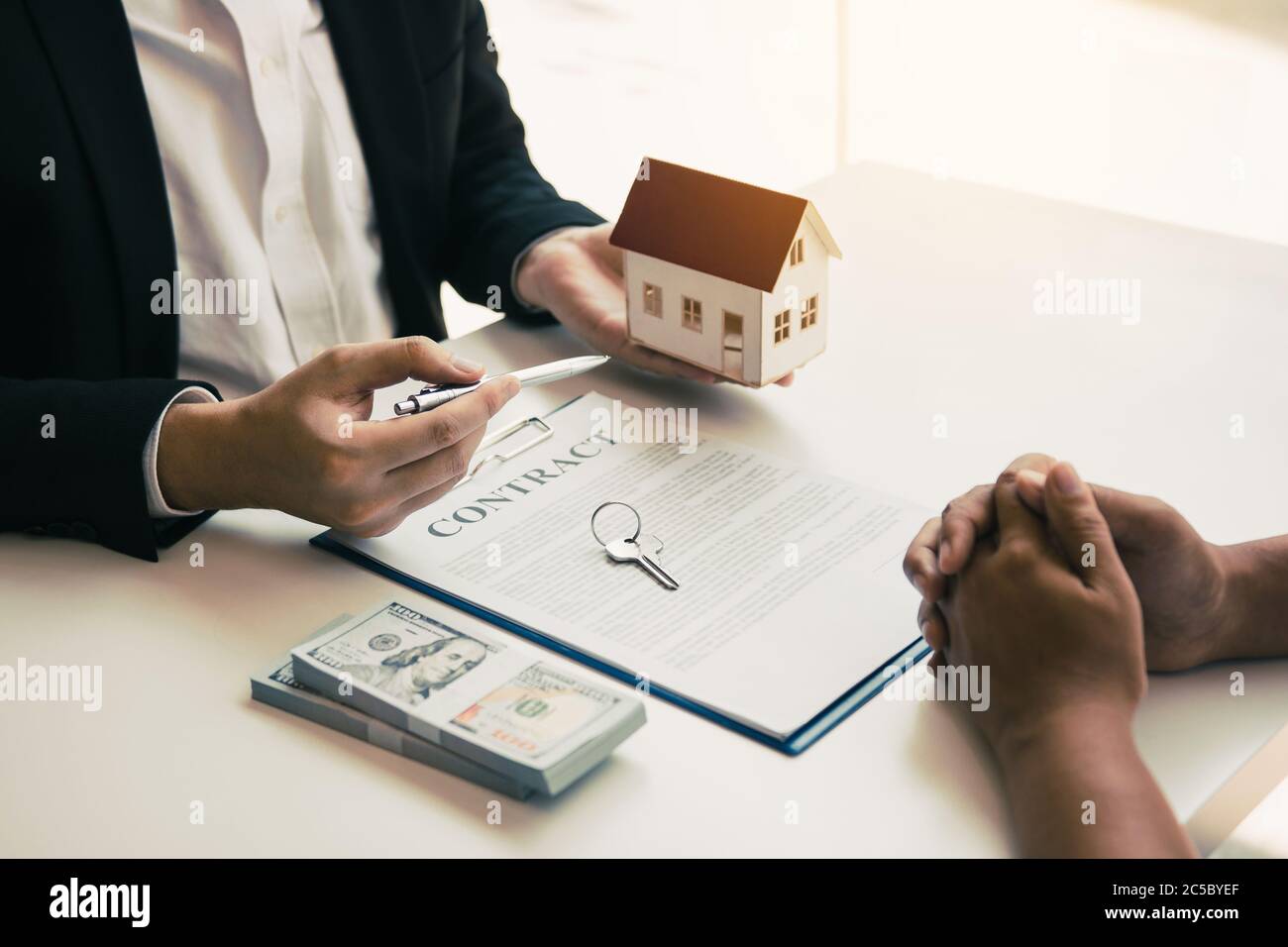 Business people home sales broker is using a pen pointing to the house ...