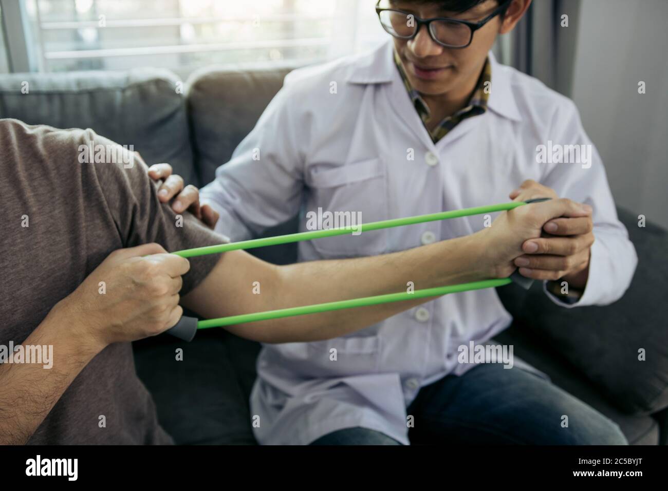 Asian male physical therapist descent working and helping to protect ...