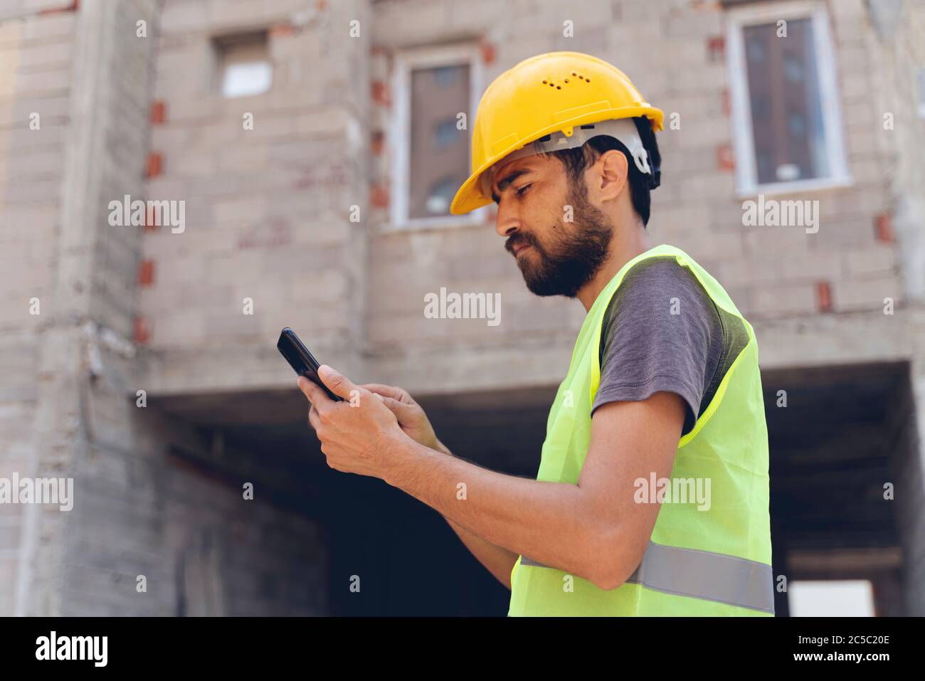 Real construction worker using mobile telephone Stock Photo - Alamy
