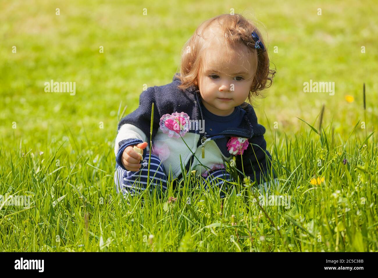 Baby on the grass in spring, note shallow depth of field Stock Photo ...