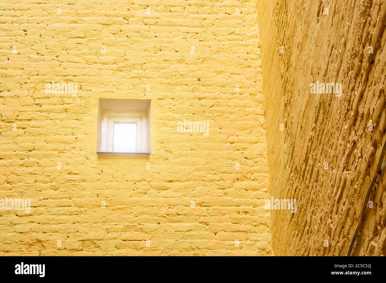 A small window in the brick wall. Corner of the house. Concept ...