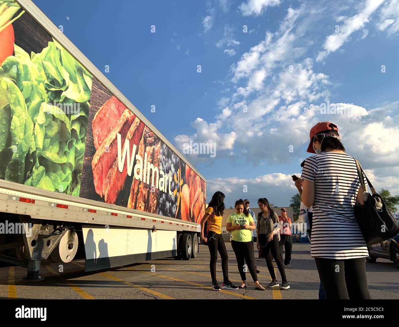 Shoppers are seen waiting a in long line outside of Walmart store, this ...