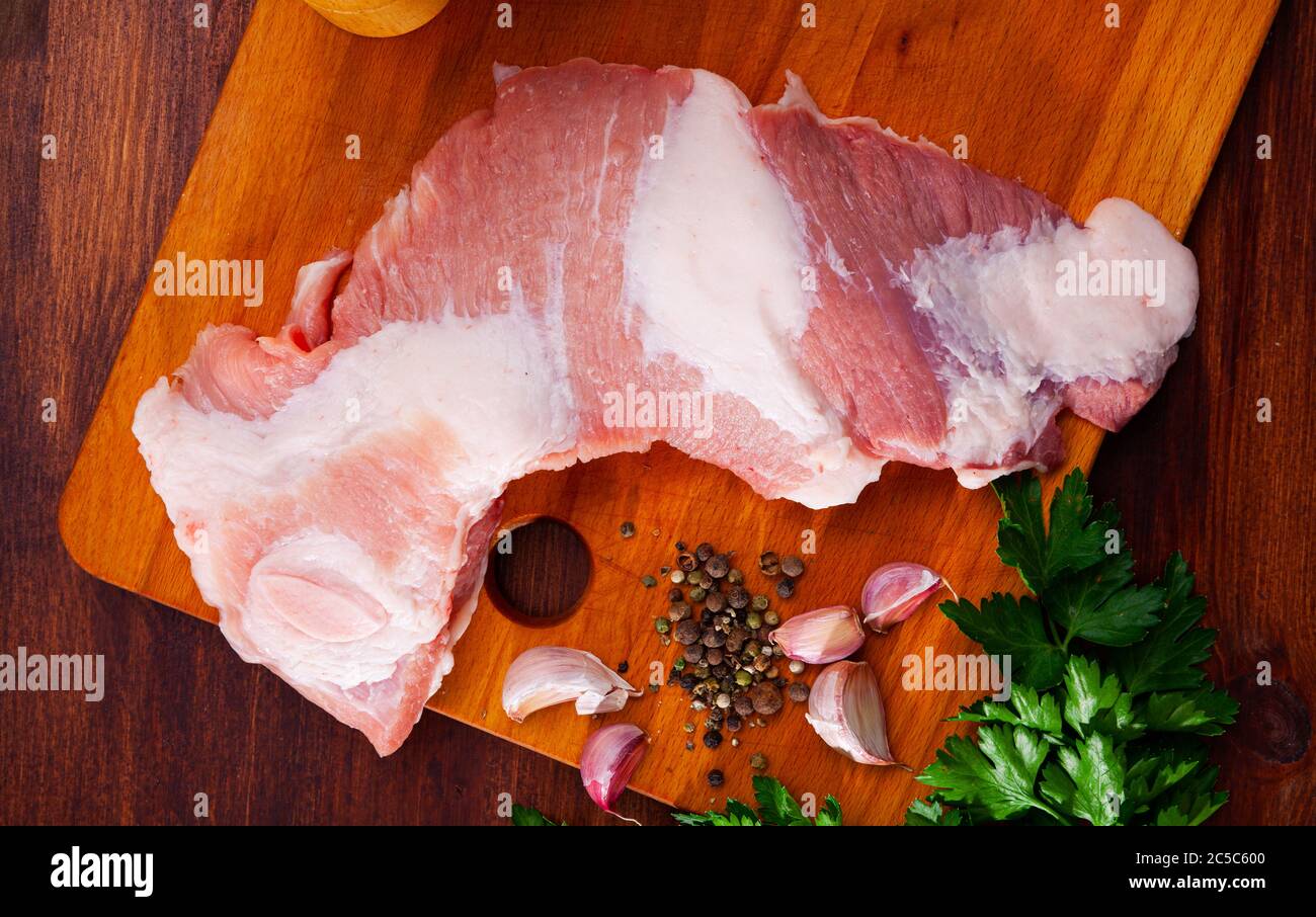 Fresh raw pork secreto meat on wooden background with herbs. Secreto is ...