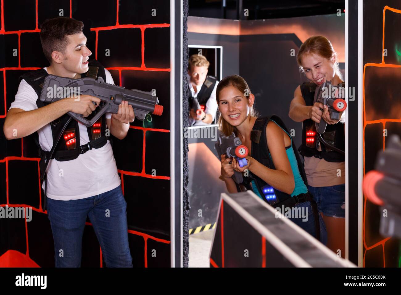 Glad players young mens and womens playing in teams in dark laser tag ...