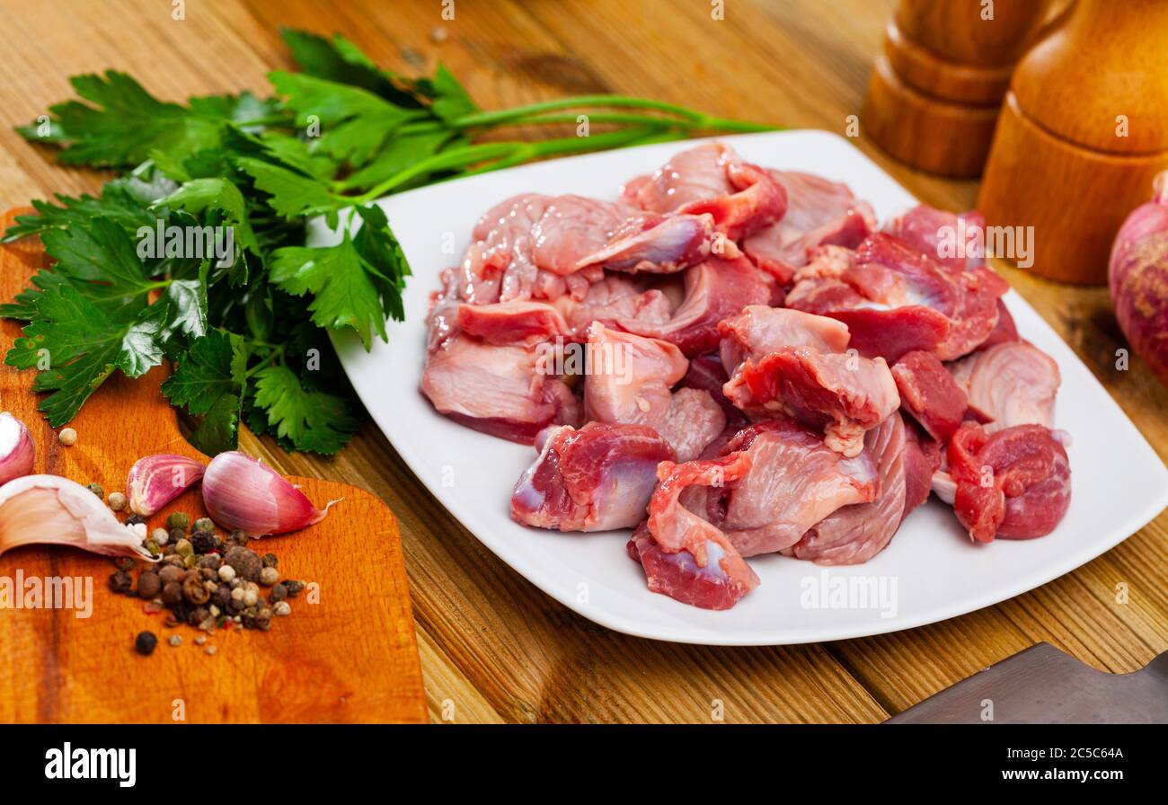 Image of raw chicken gizzards before cooking on table with greens Stock ...
