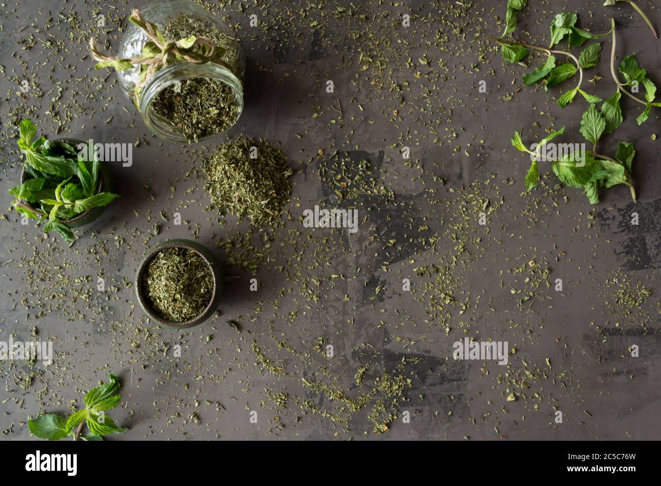 Dried peppermint in a bowl and a bunch of fresh mint, on gray ...