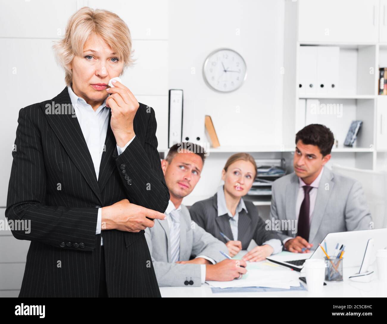 Business team tensely solving problems in office with upset woman ...